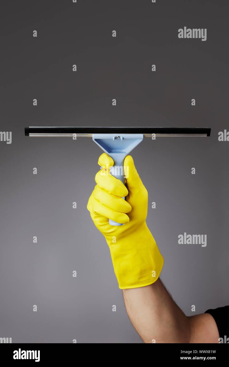 A gloved hand holding a squeegee Stock Photo - Alamy