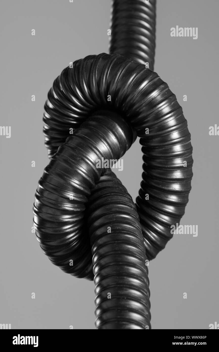 Knot on a flexible plastic hose. Black & white image Stock Photo - Alamy