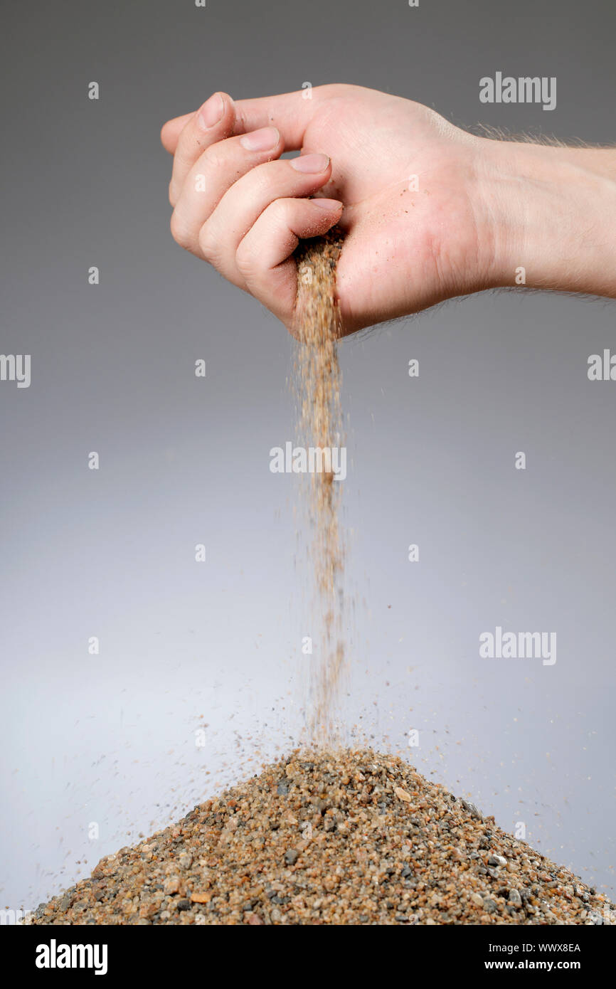 Man adding sand in a heap with his hand Stock Photo - Alamy