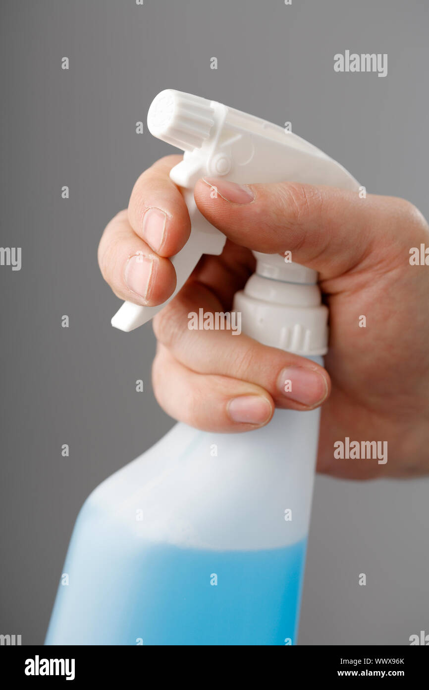 Hand holding a plastic spray bottle filled with blue liquid Stock Photo ...