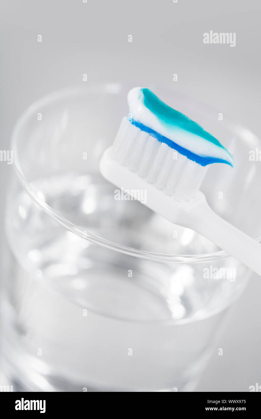 Toothbrush with toothpaste and a glass of water Stock Photo - Alamy
