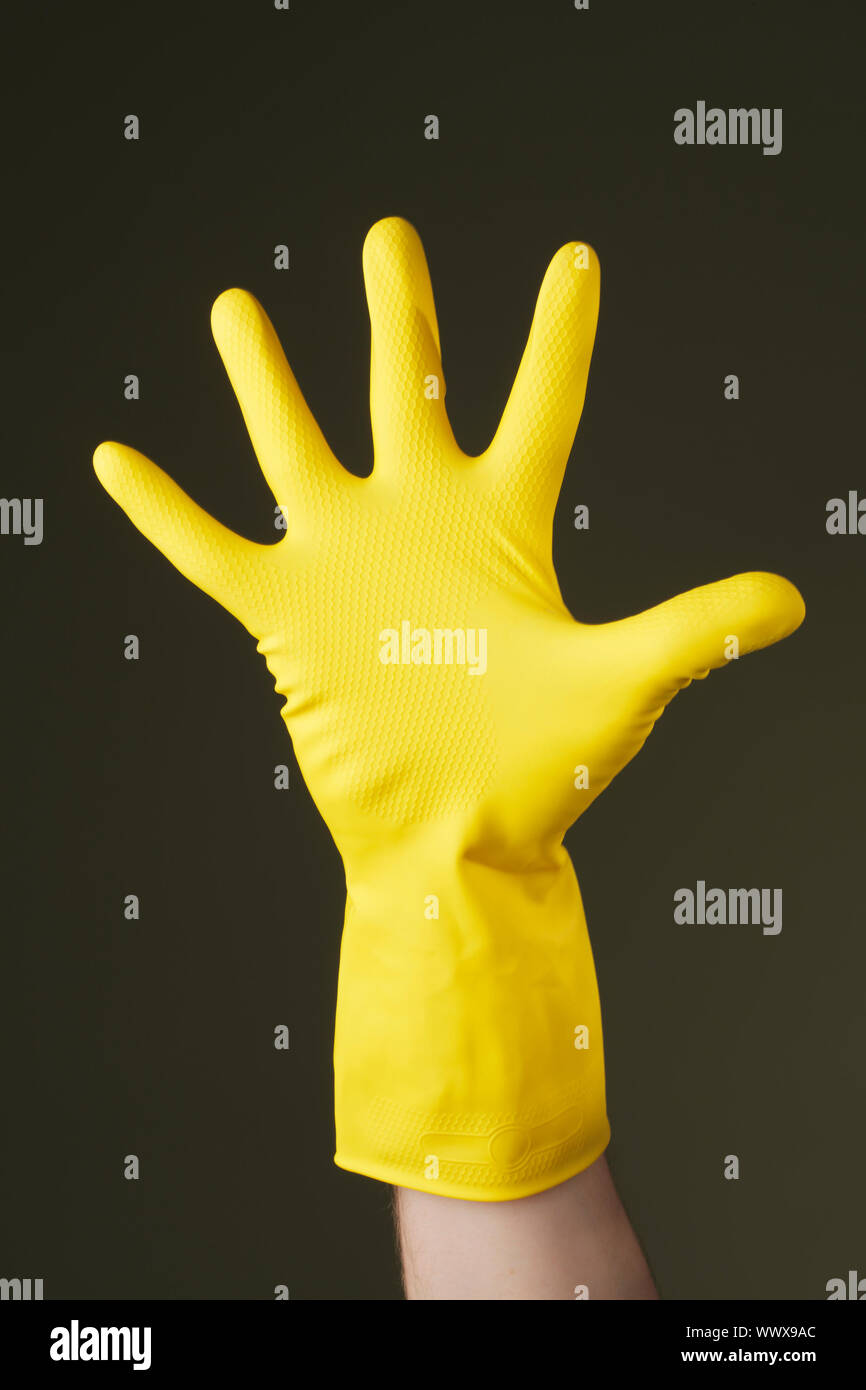Hand with a protective yellow rubber glove Stock Photo - Alamy