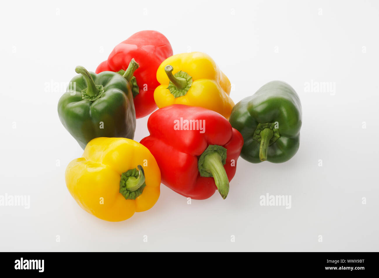 Different colors of bell peppers on light gray surface Stock Photo - Alamy