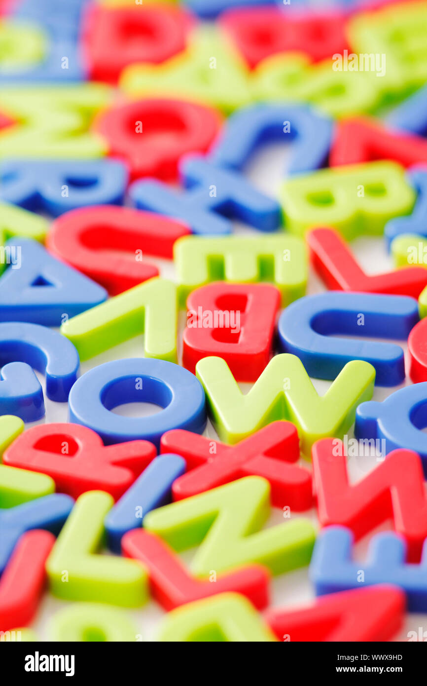 Random colored plastic letters on white background, short depth-of ...