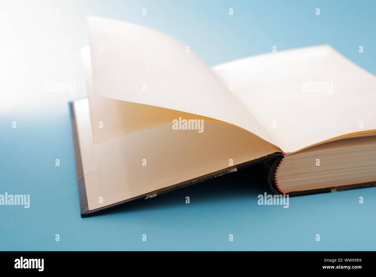 An old open book on blue background Stock Photo - Alamy