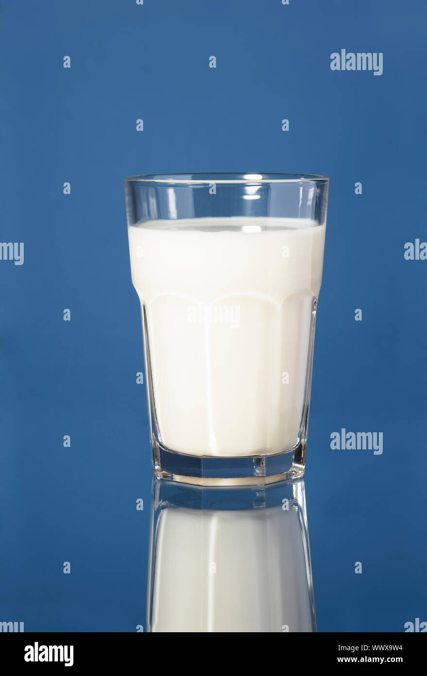 A Glass of milk on blue reflective surface Stock Photo - Alamy
