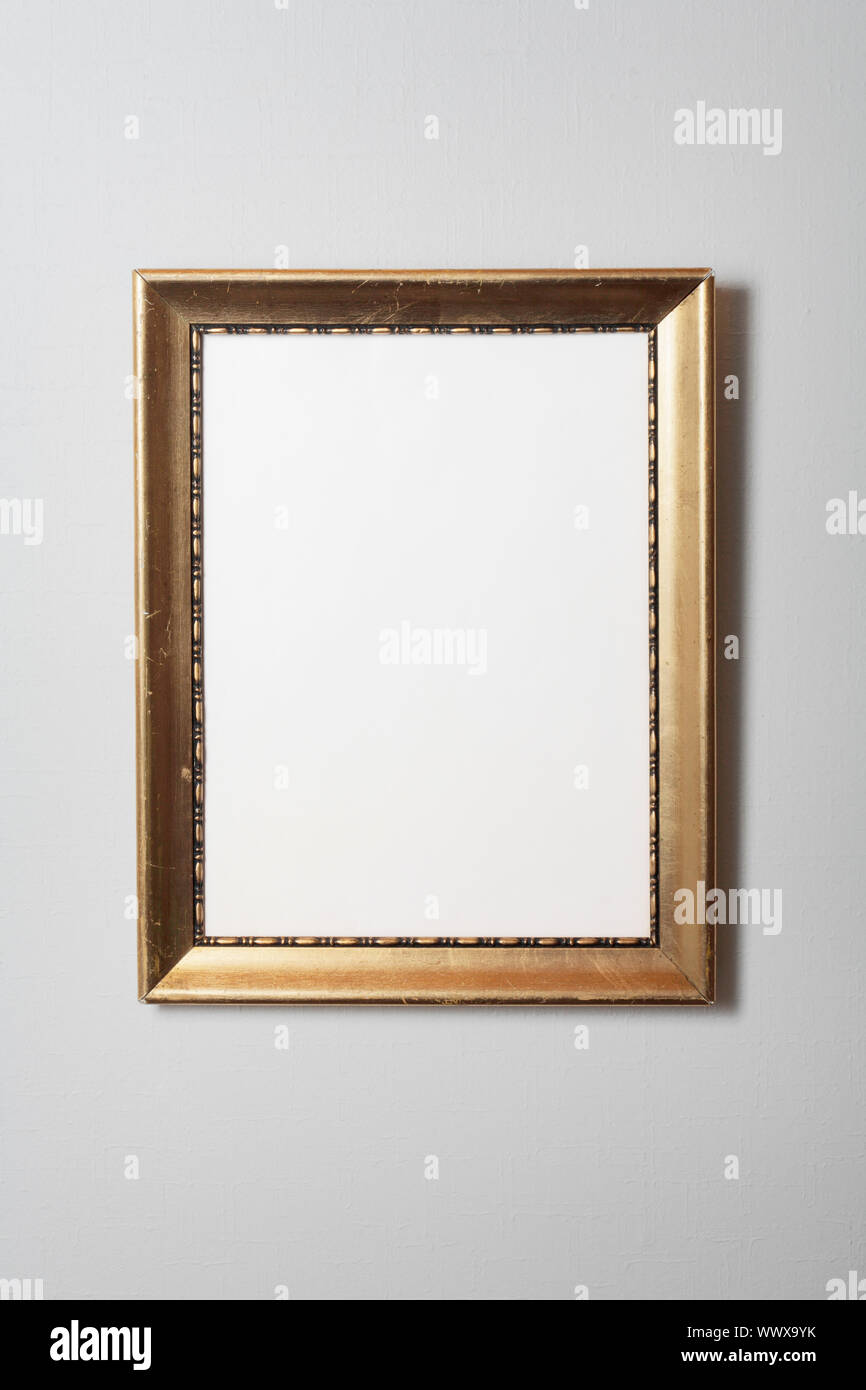 Old golden colored worn and dirty frame hanging on a wall Stock Photo ...