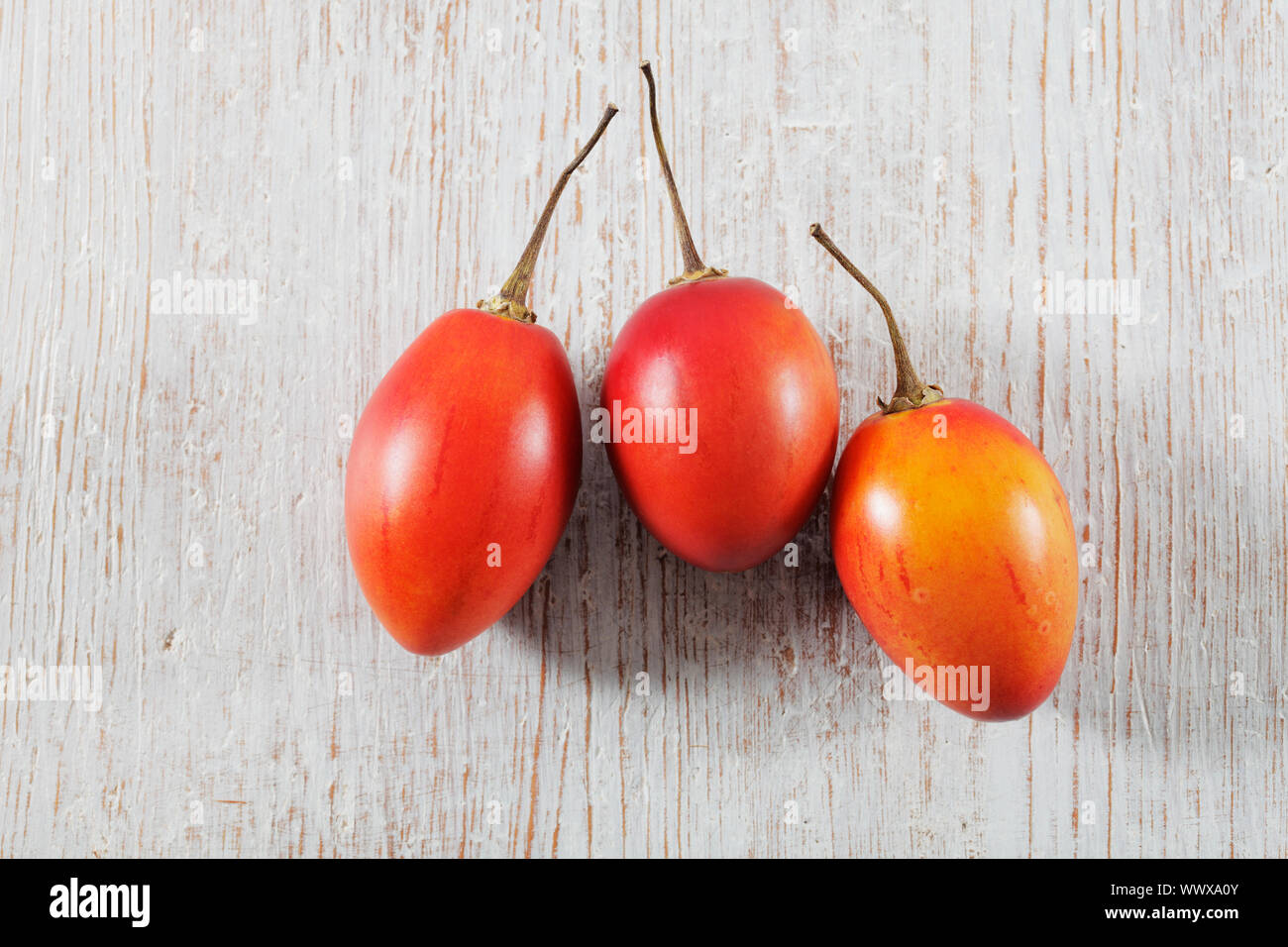Three Tamarillo fruit (tree tomato) on white wooden background Stock ...