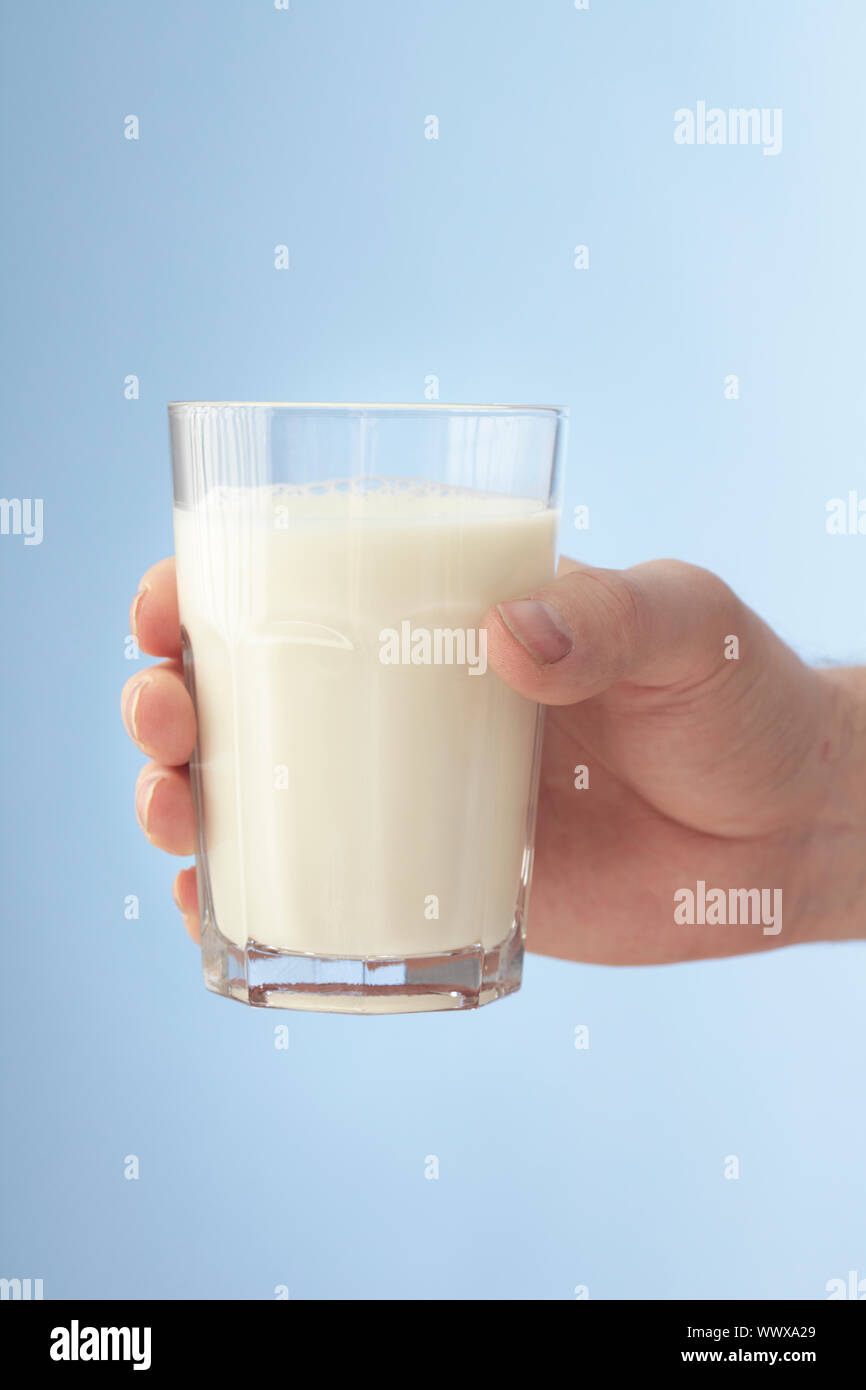 A Glass of milk held by a hand Stock Photo - Alamy