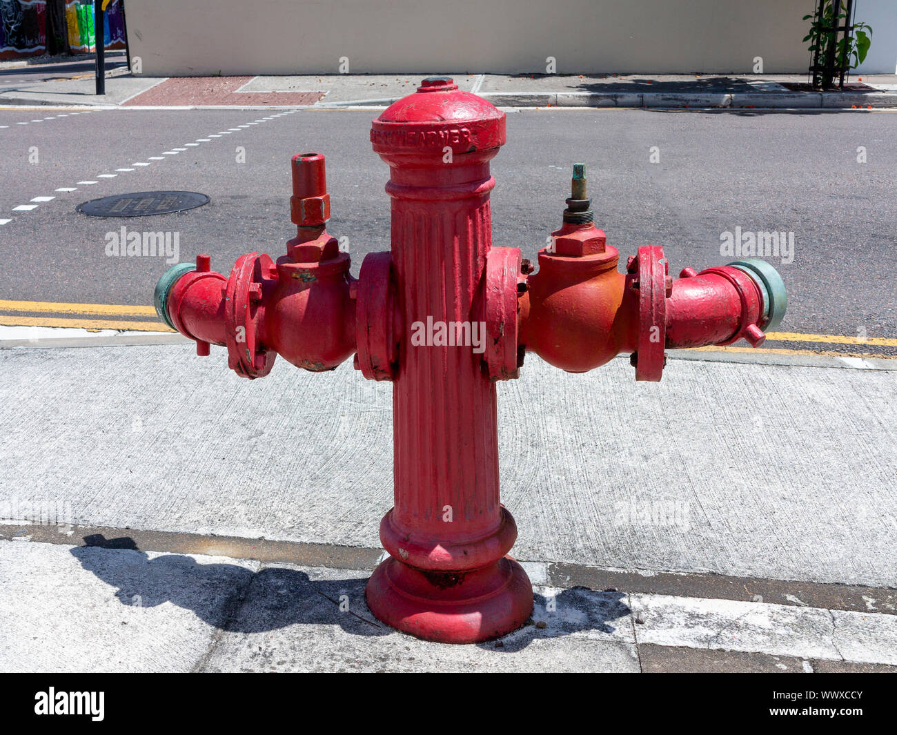 Two sided red roadside fire hydrant on a pavement in Hamilton Bermuda ...