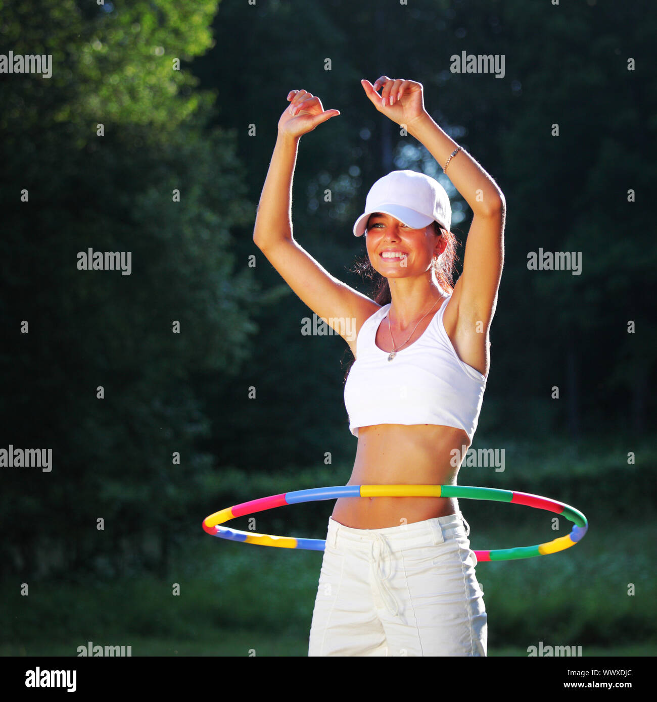 woman rotates hula hoop on nature background Stock Photo - Alamy