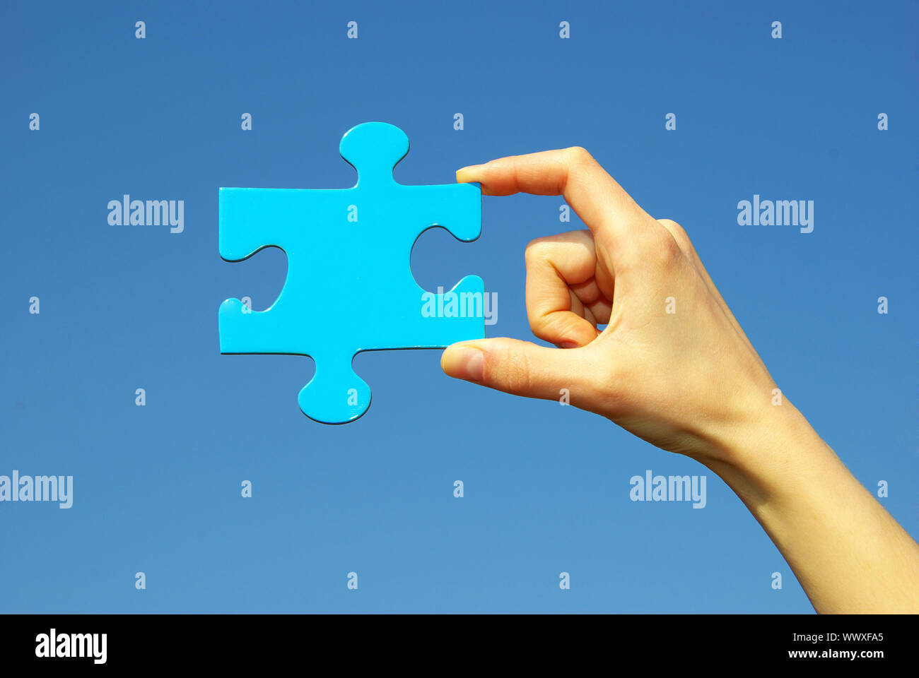 puzzle in hand isolated on sky background Stock Photo - Alamy
