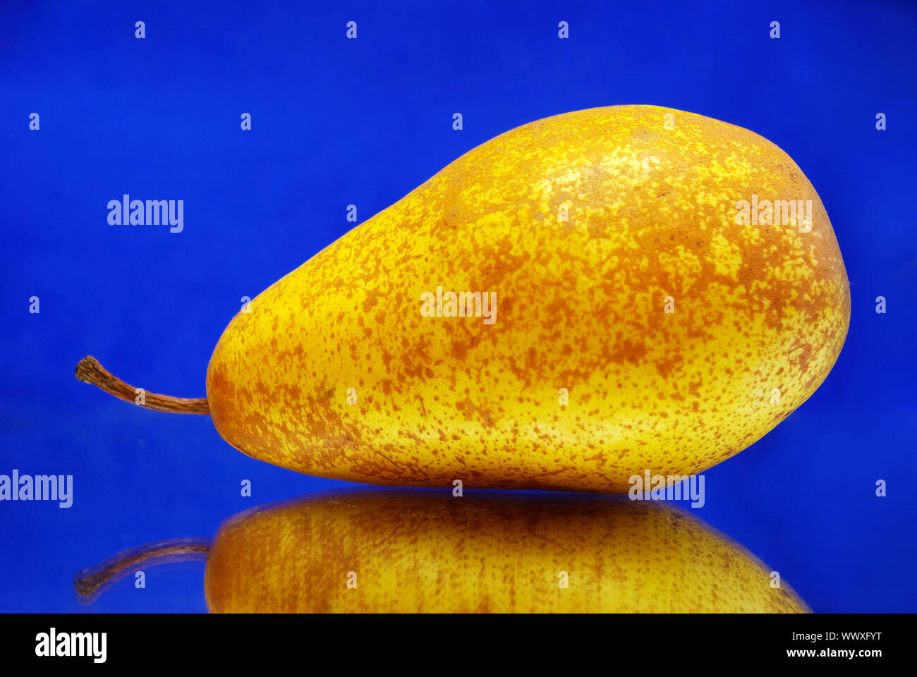 yellow pear isolated over blue Stock Photo - Alamy