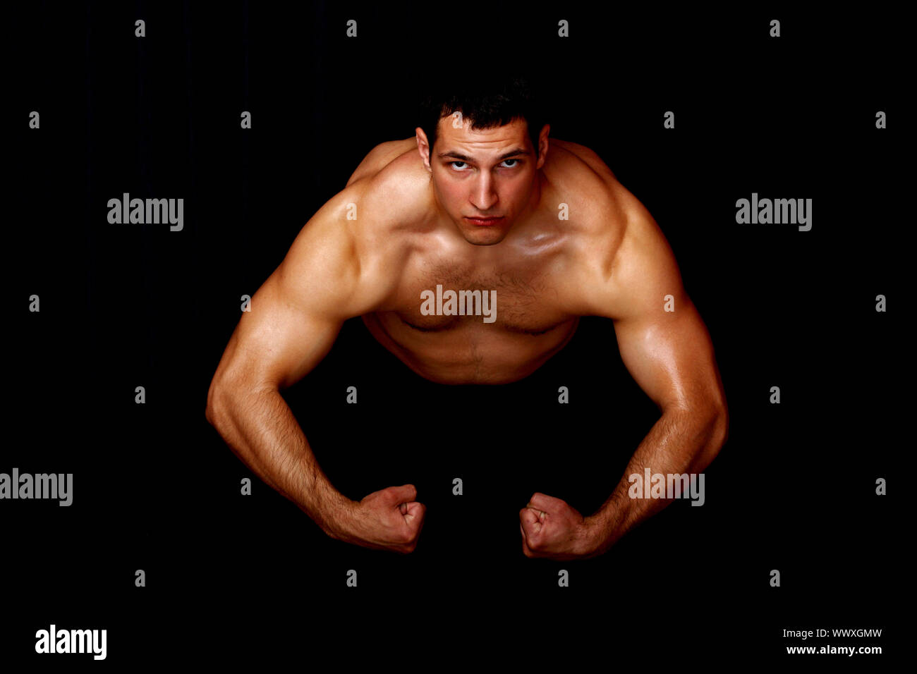 bodybuilder showing his strength, on black background Stock Photo - Alamy