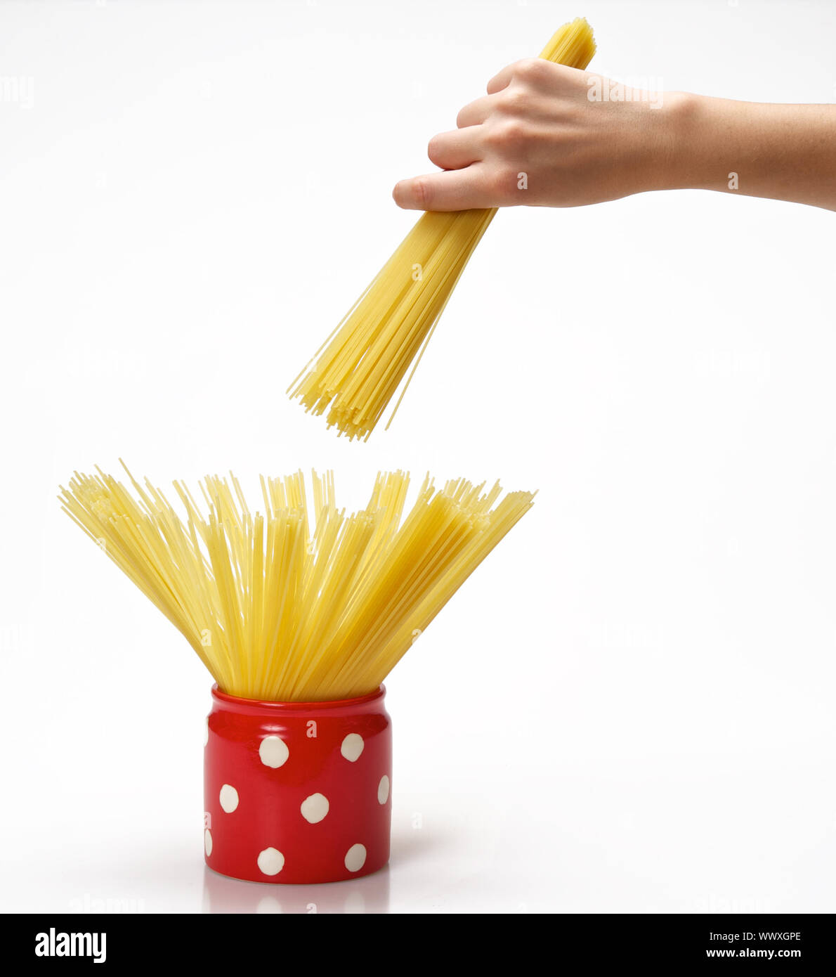 Woman's hands holding red jar full of spaghetti inside. Isolated on a ...
