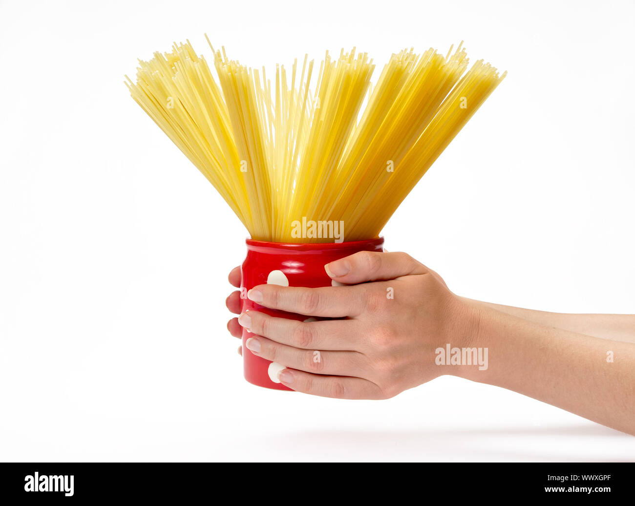 Woman's hands holding red jar full of spaghetti inside. Isolated on a ...