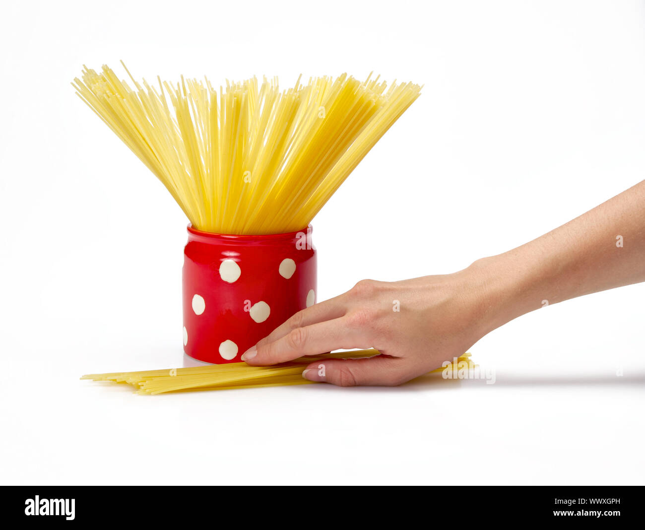 Woman's hand holding red jar full of spaghetti inside. Isolated on a ...