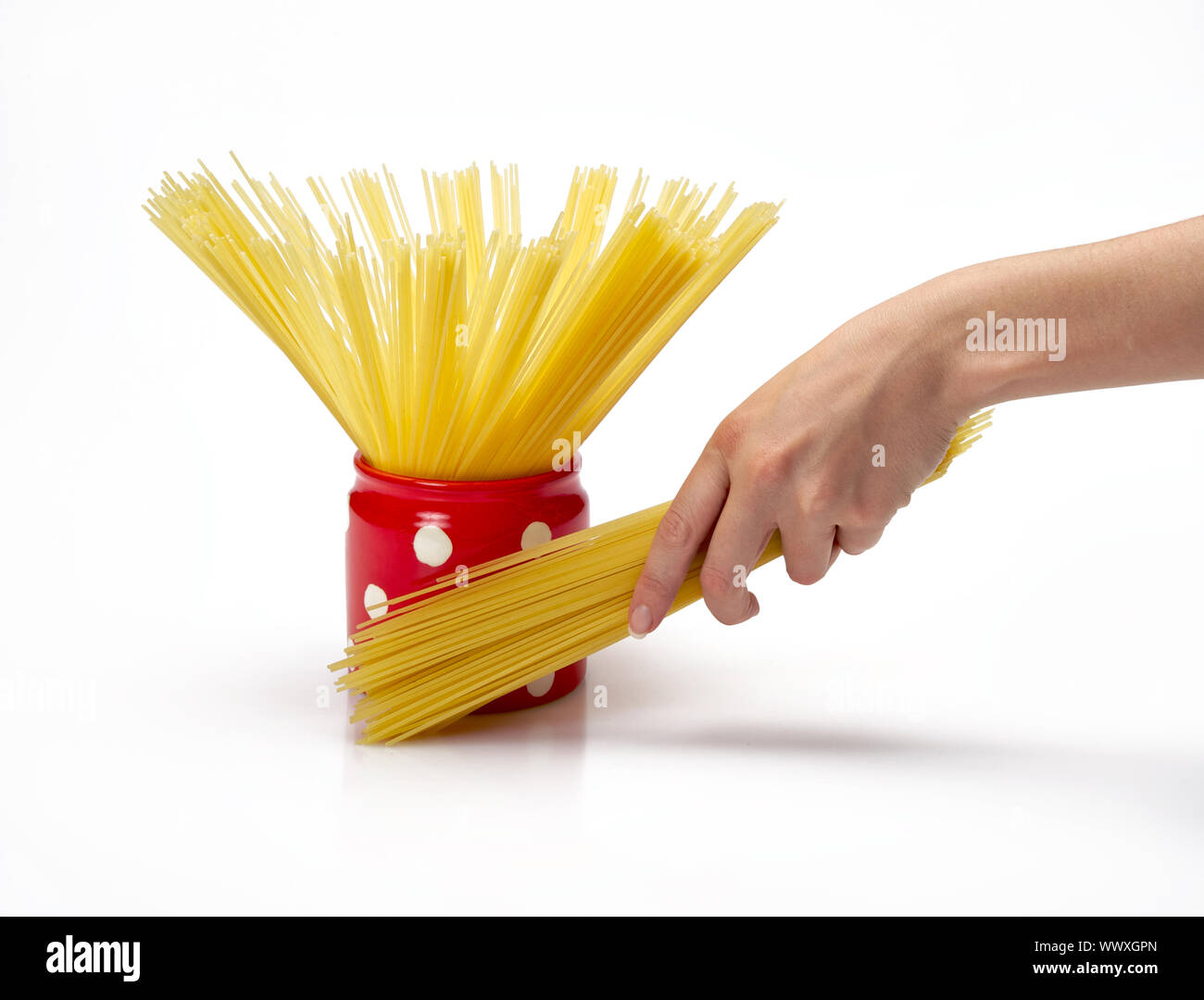 Woman's hands holding red jar full of spaghetti inside. Isolated on a ...