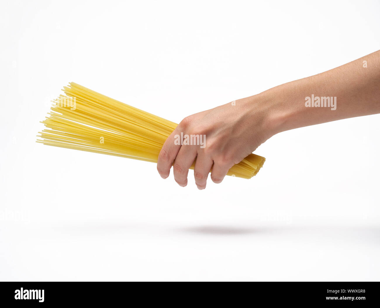 Woman's hand holding bunch of spaghetti. Isolated on a white background ...