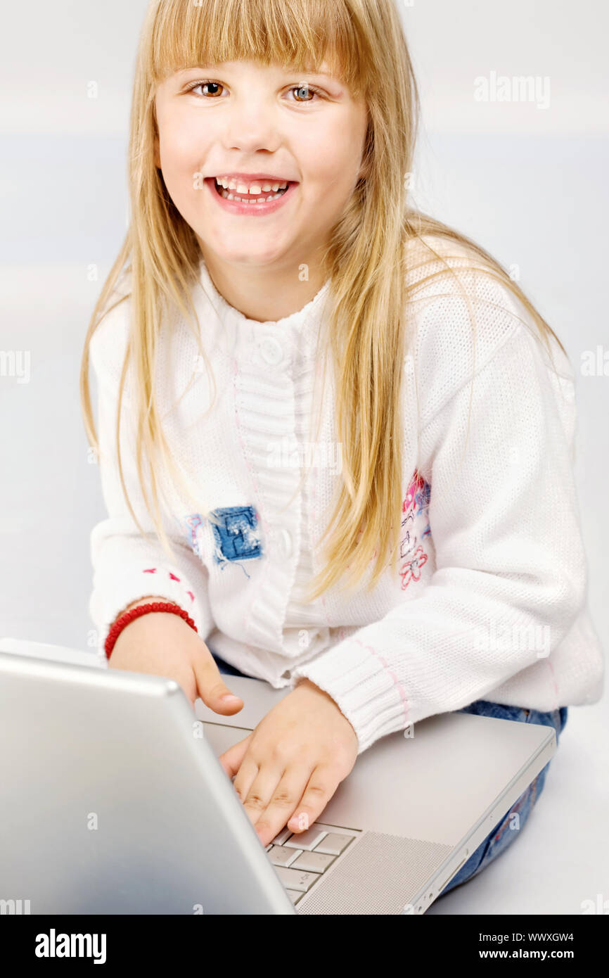 Smiled female child holding laptop Stock Photo - Alamy