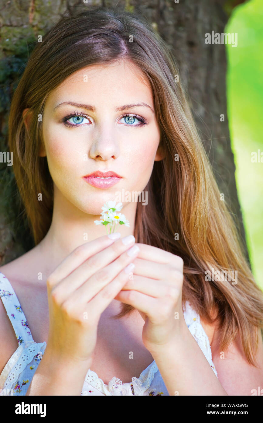 Pretty brunette woman in park holding spring flowers, outdoor Stock ...