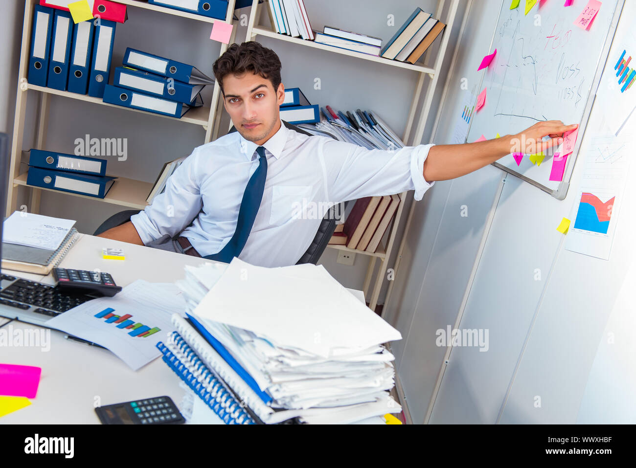 Businessman working in the office with piles of books and papers Stock ...