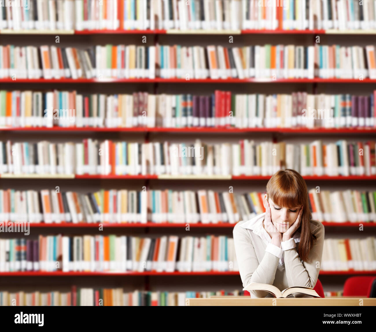 Portrait of a serious young student reading a book in a library Stock ...