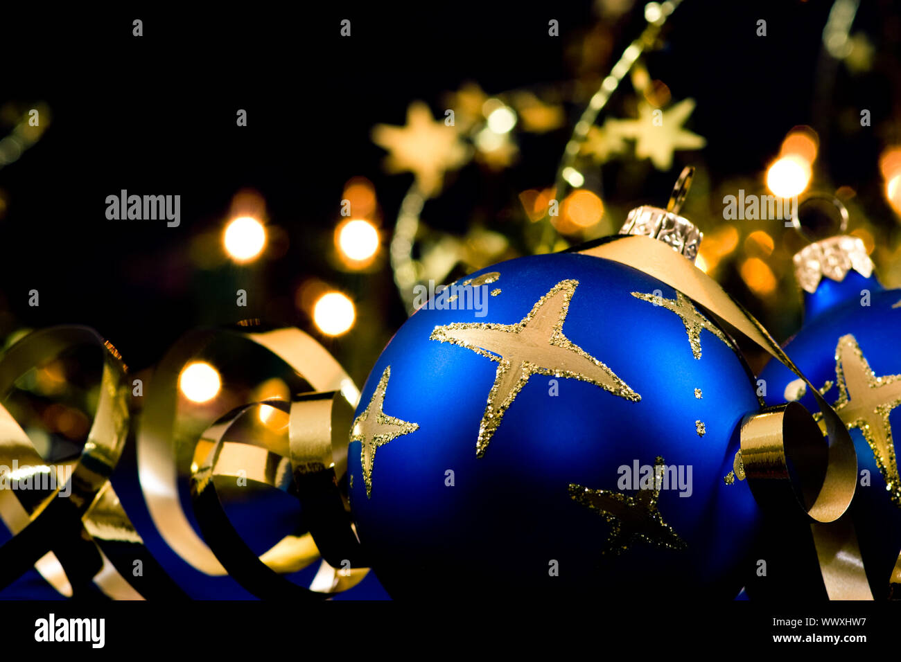 Christmas blue baubles with blurred lights in background, selective ...