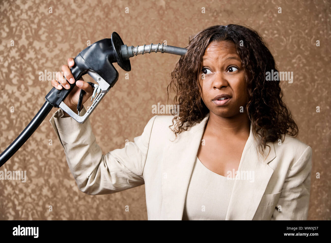 Woman holding gas nozzle like a gun to her head Stock Photo - Alamy