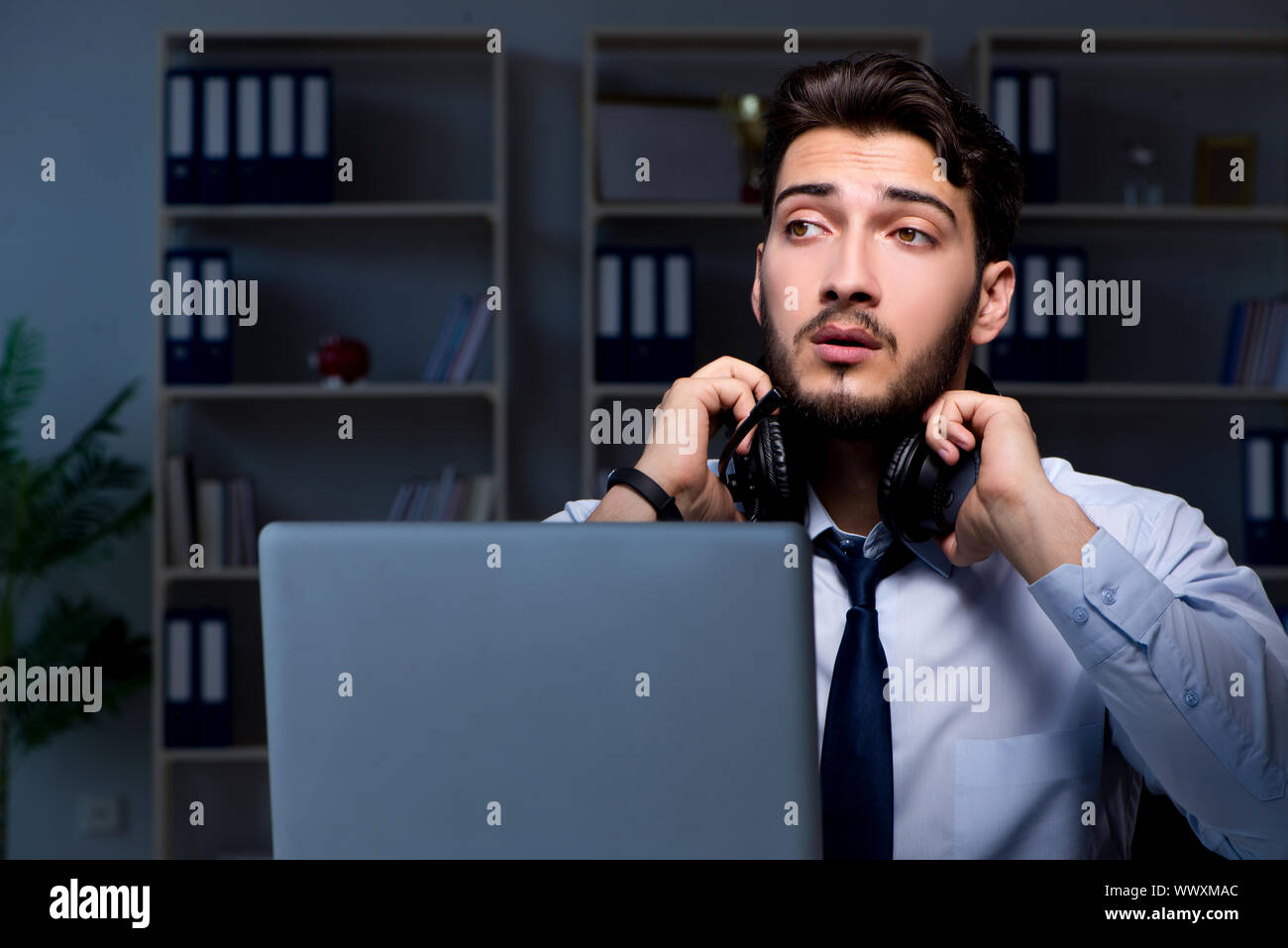 Young man in call center concept working late overtime in office Stock ...