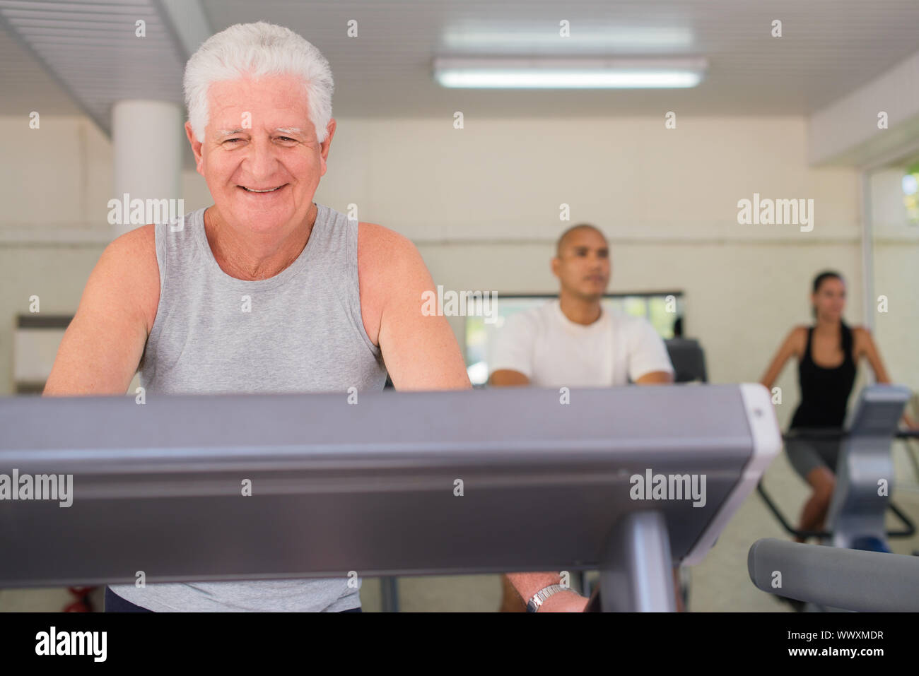 People and sports, elderly man working out on treadmill in fitness gym ...