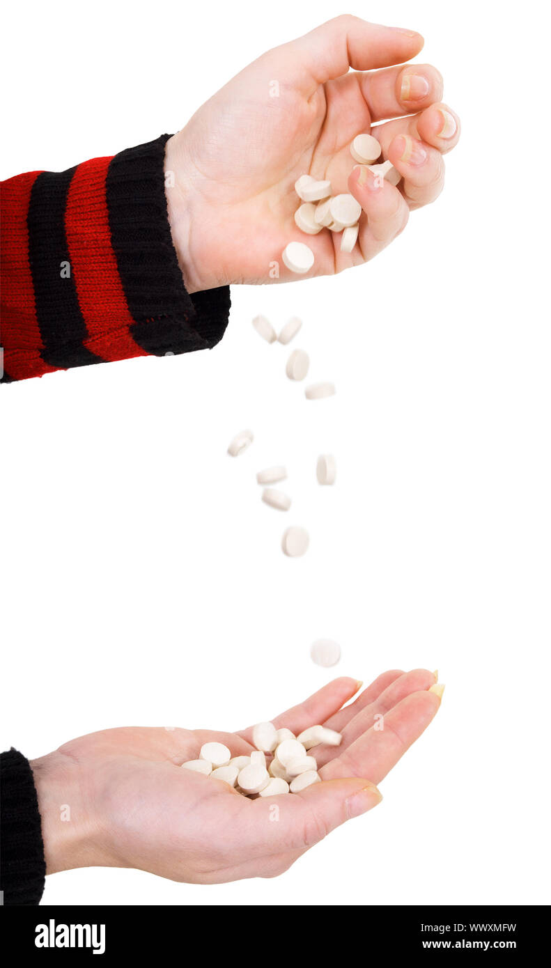 Tablets falling from one hand on other hand Stock Photo - Alamy