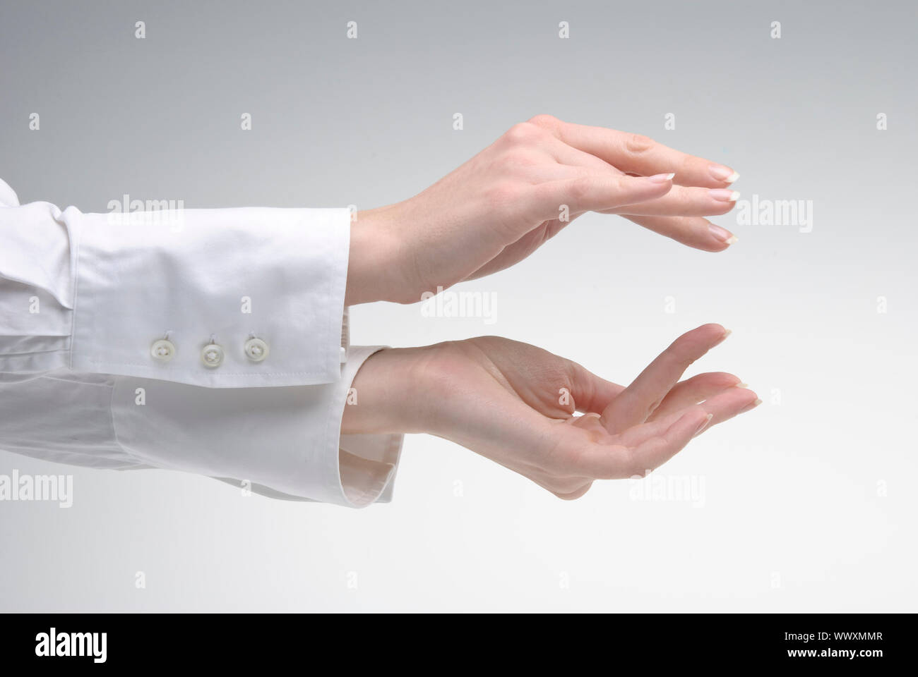 Woman's hand showing symbol small over light background Stock Photo - Alamy