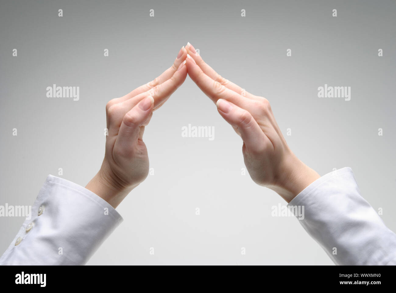 Woman's hand showing roof symbol over light background Stock Photo - Alamy