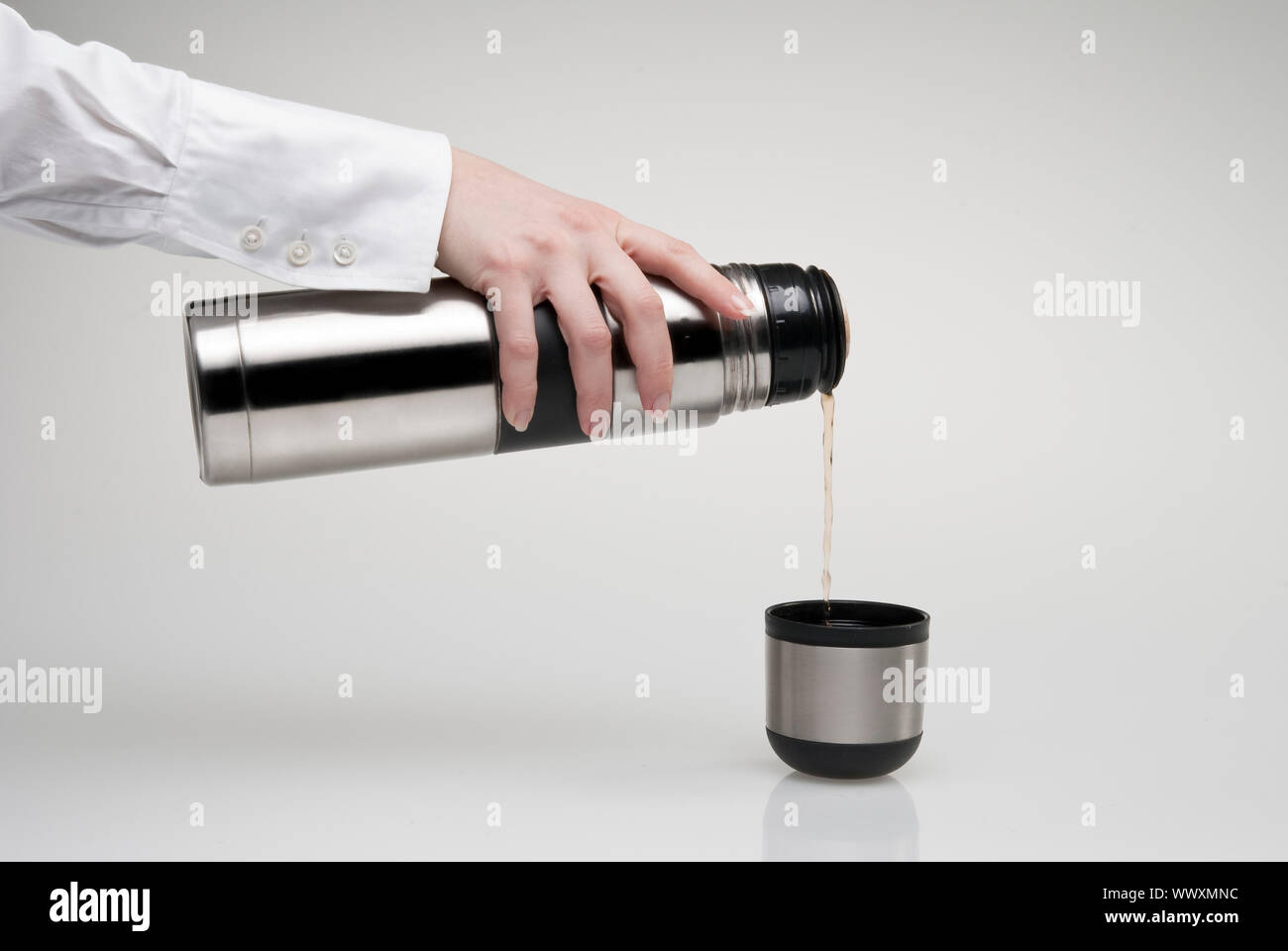 Female hand pouring tea from thermos Stock Photo - Alamy