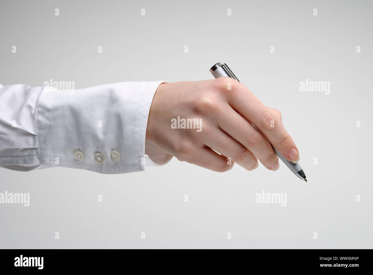 Woman's hand holding silver pen over light background Stock Photo - Alamy