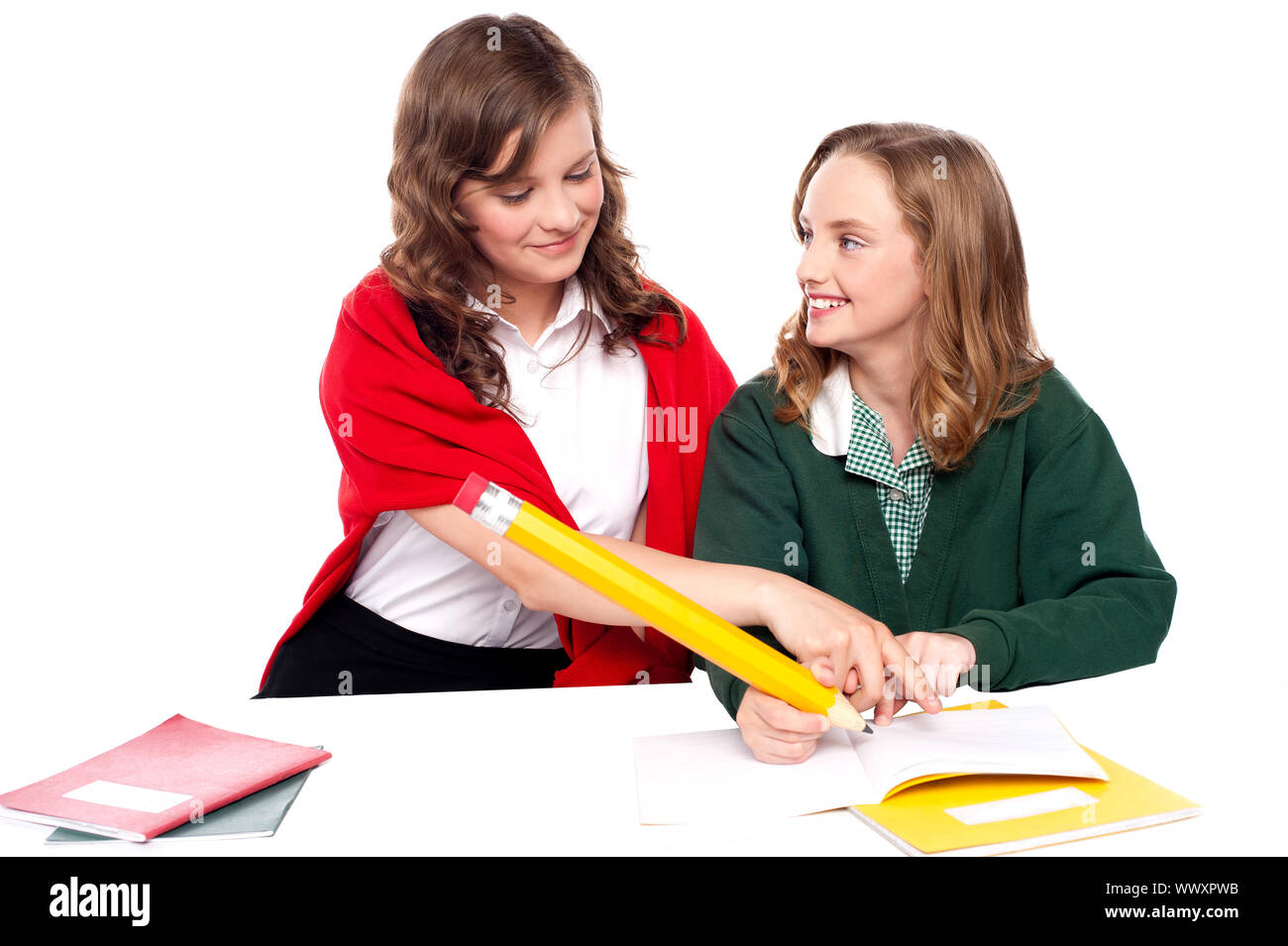 Girl explaining solution to her friend and helping her resolve question ...