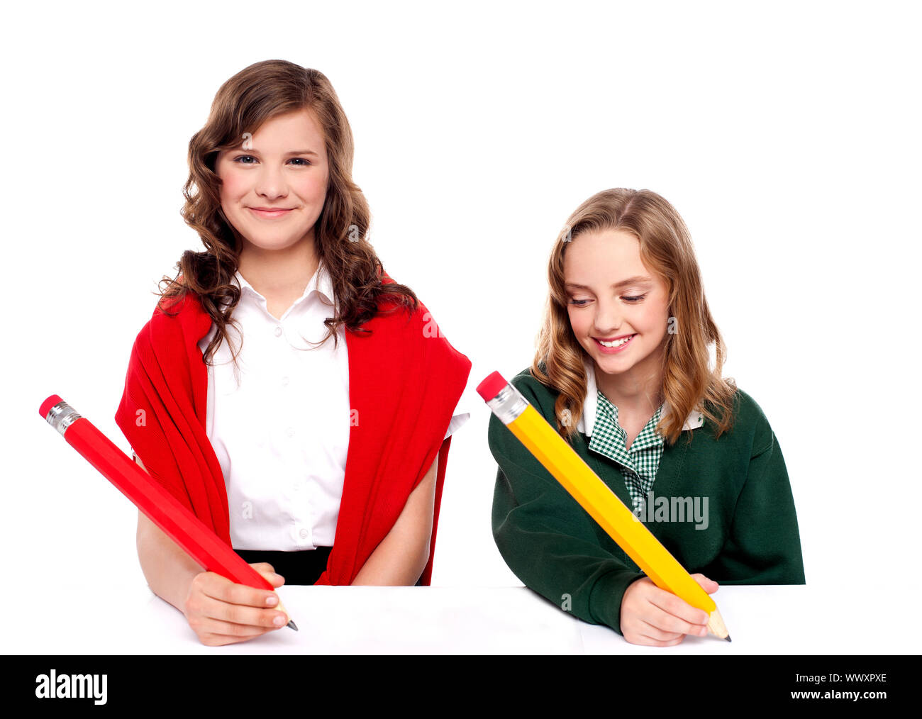 Cheerful girls writing with pencil on surface isolated against white ...