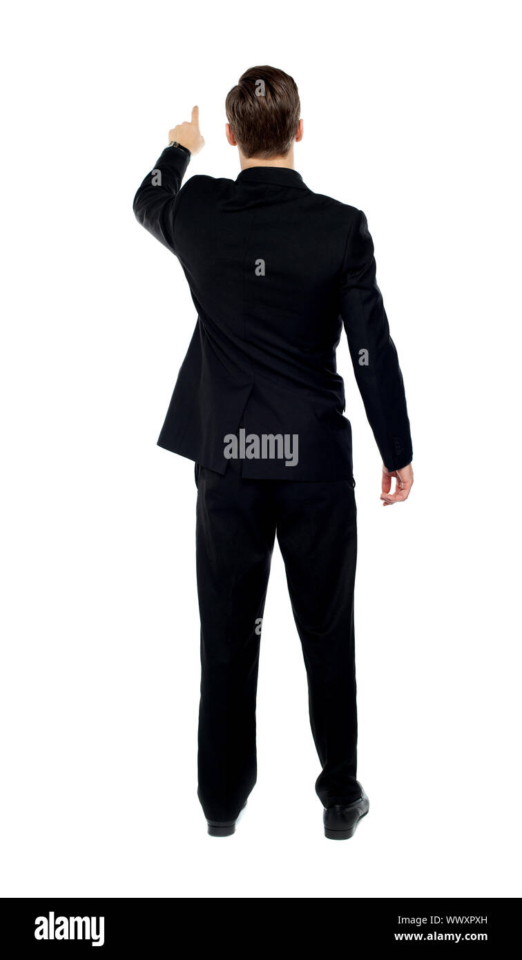 Rear view of a male model pointing at copy space over white background ...