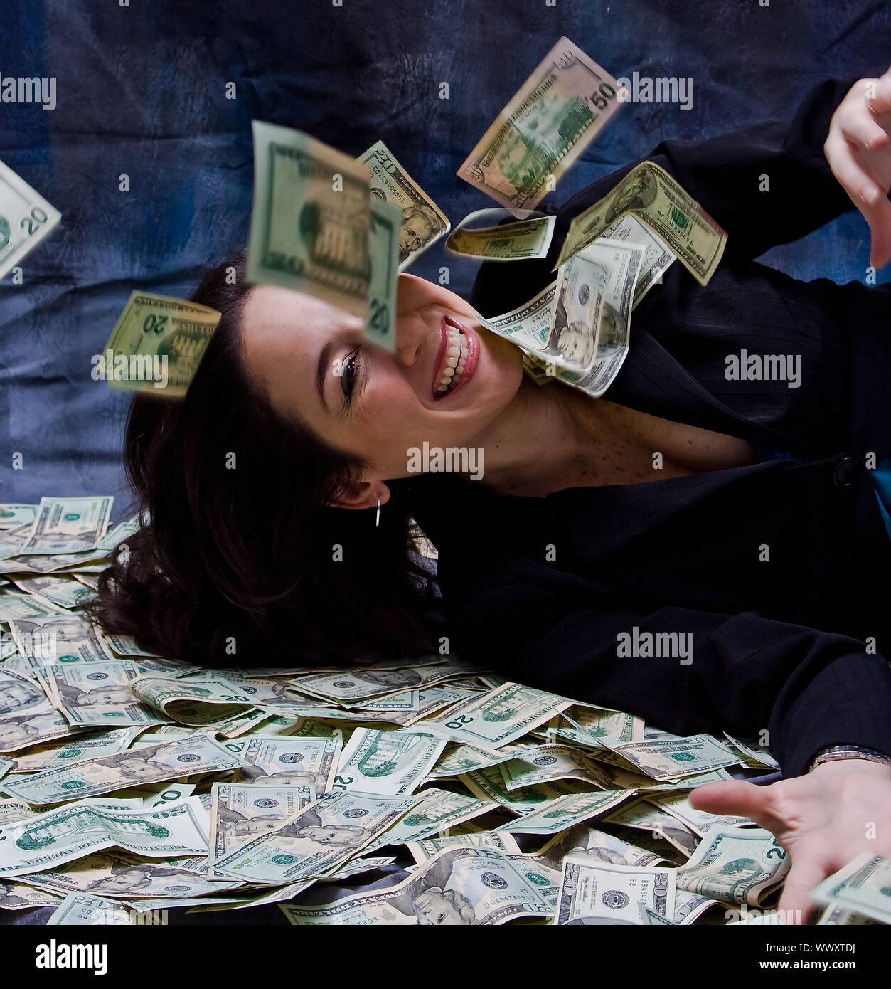 Rich business woman waving laying with her money, she smiles as money ...
