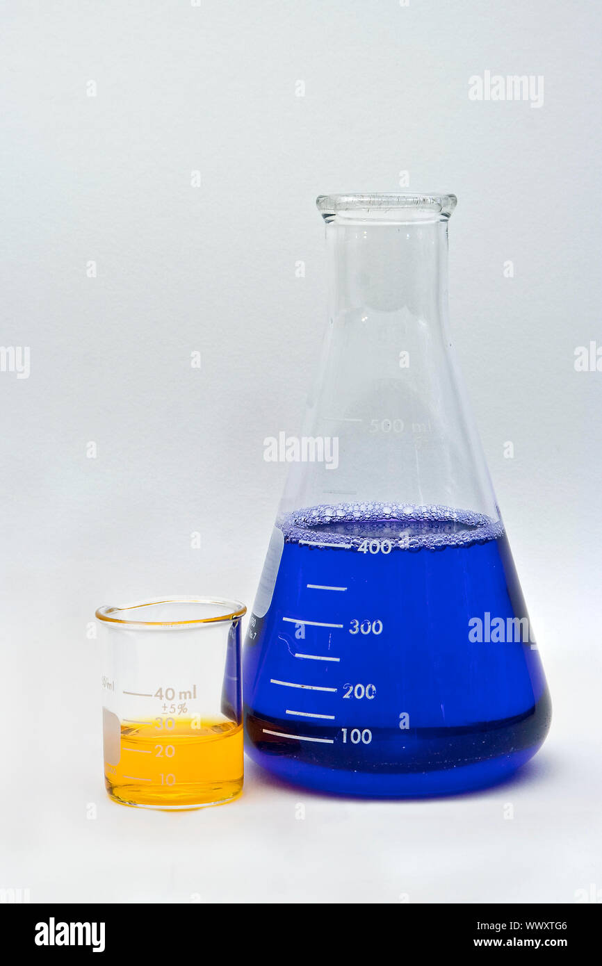 Flask and beaker with colorful liquids as pH indicators on a white ...