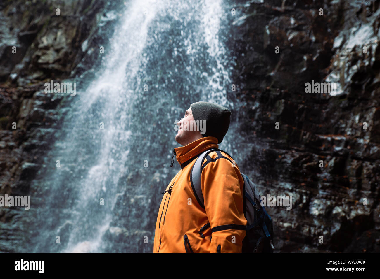 man hiking concept looking at waterfall in dip forest Stock Photo - Alamy