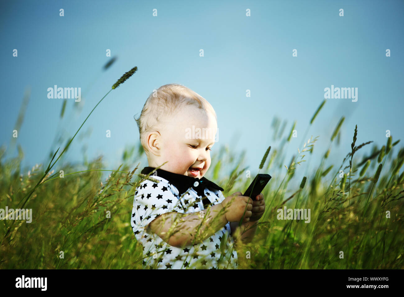 little boy in green grass call by phone Stock Photo - Alamy