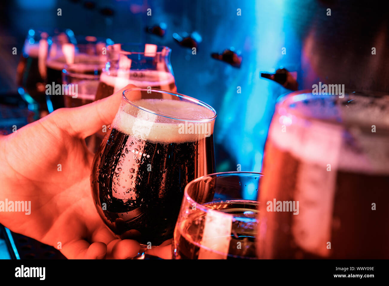 Hand of bartender pouring a large ale, porter, stout beer in tap ...