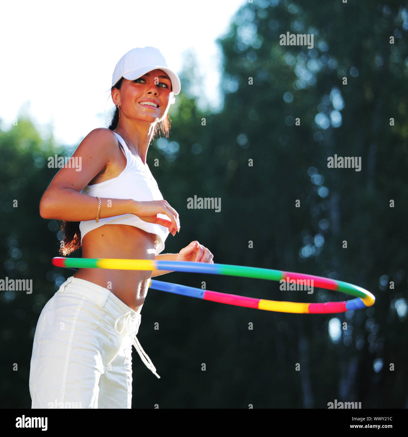 woman rotates hula hoop on nature background Stock Photo - Alamy