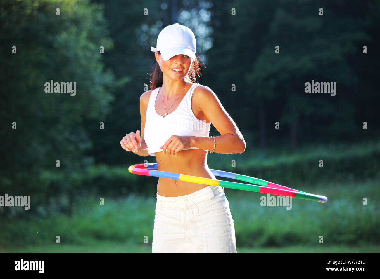 woman rotates hula hoop on nature background Stock Photo - Alamy