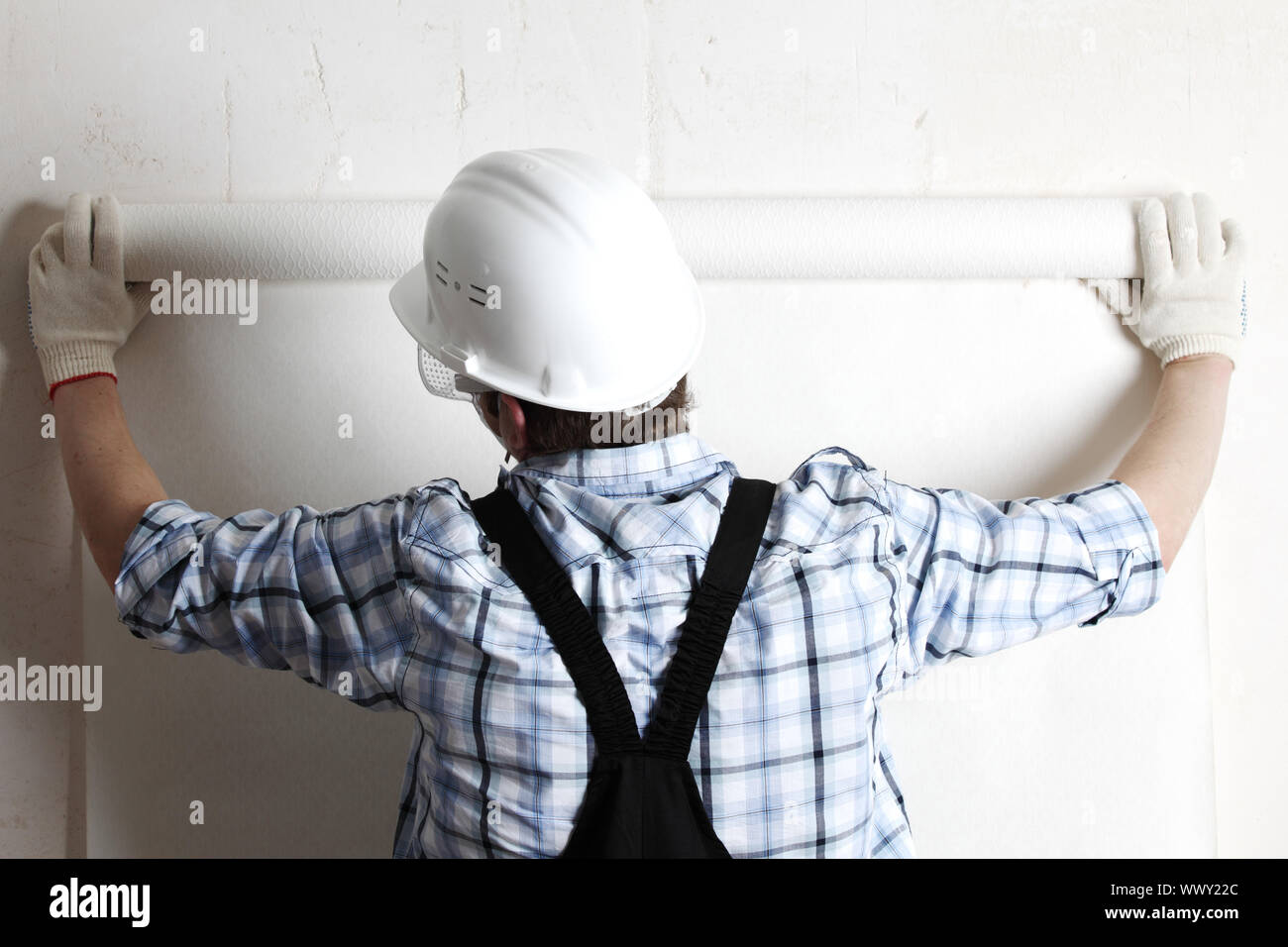 worker attaching wallpaper to wall Stock Photo - Alamy