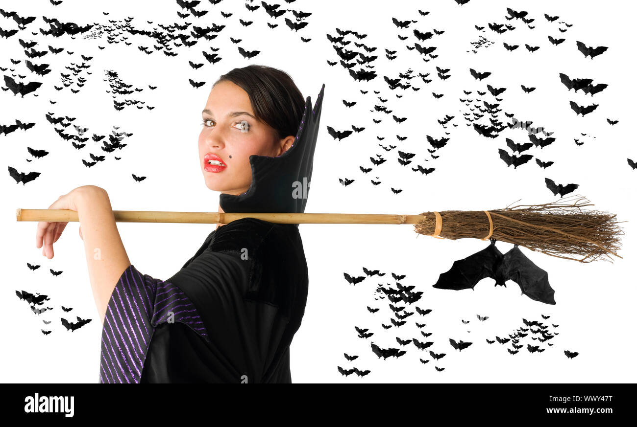 pretty witch in black dress with her broom on shoulder and black bat ...
