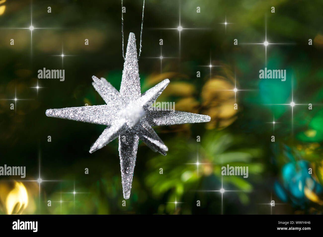 Decorative silver Star ornament in a Christmas tree in front of a ...