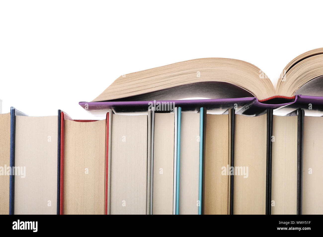 Open book resting on stack of books.white background Stock Photo - Alamy
